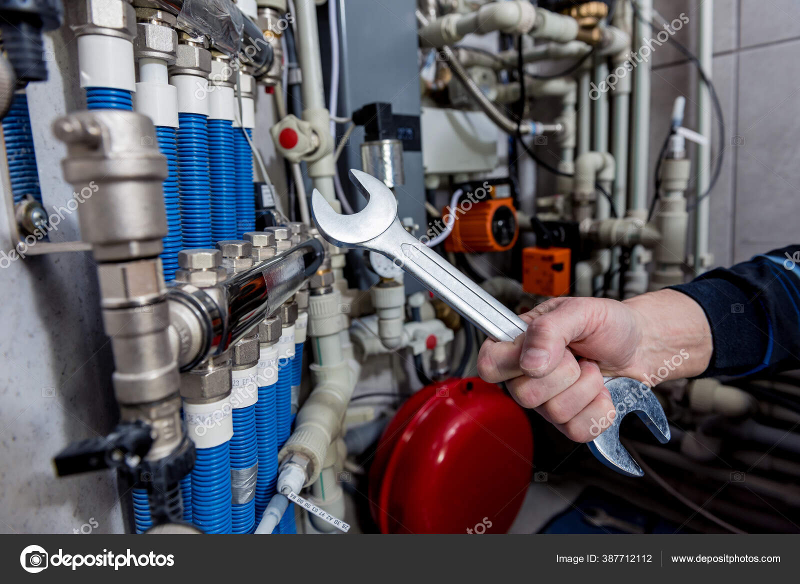 Heating engineer fixing modern heating system in boiler room. — Stock ...