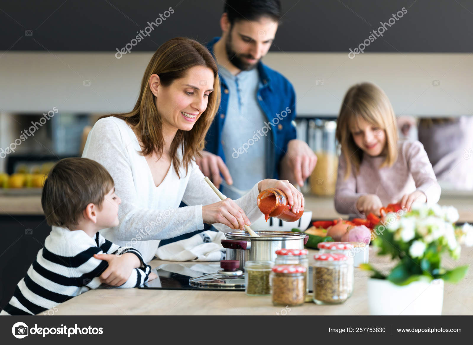 Beautiful cute family having fun while cooking together in the kitchen ...