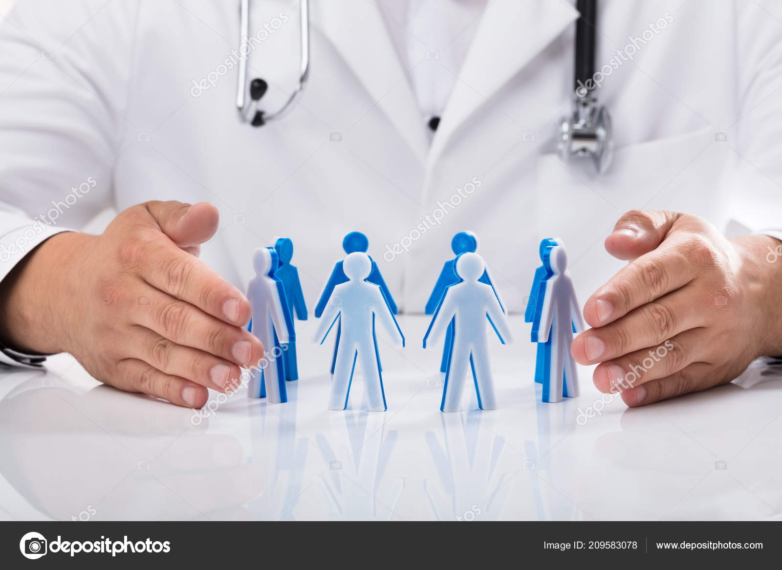 Doctor's Hand Protecting Human Figures Forming Circle Desk Stock Photo ...