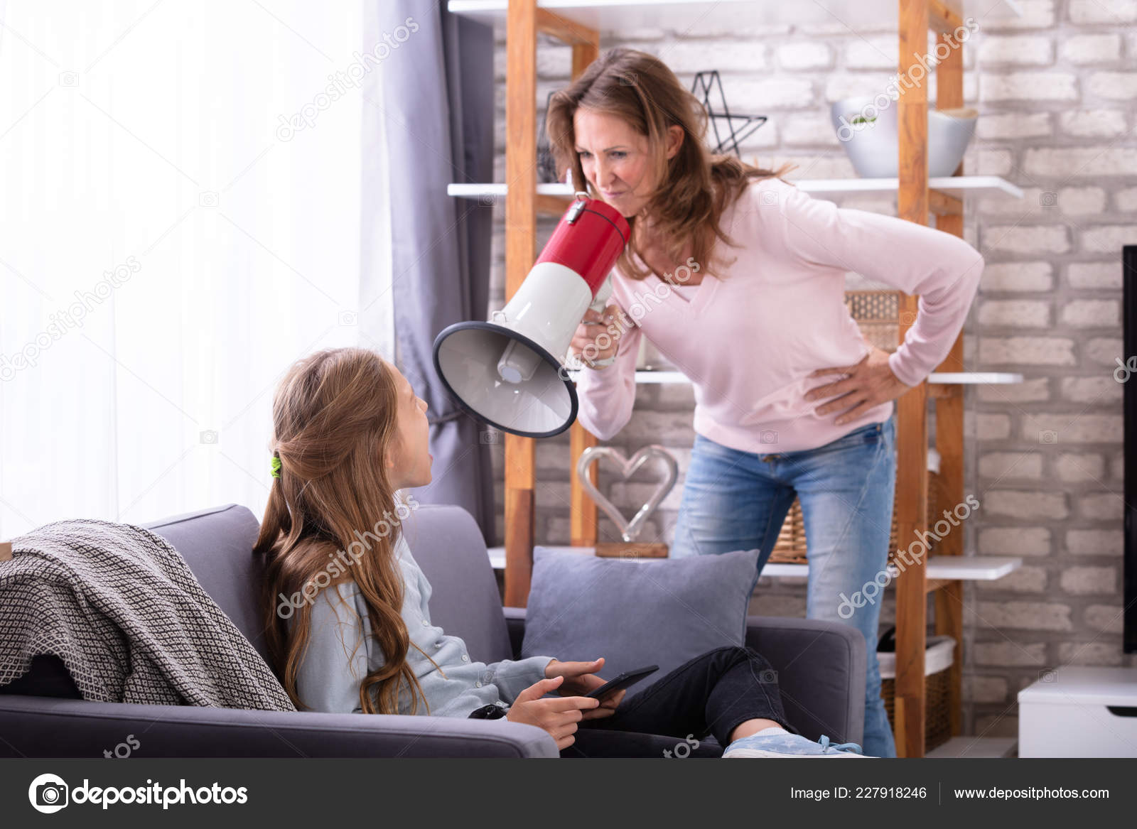 Mother Shouting Megaphone Careless Girl Sitting Sofa Using Digital
