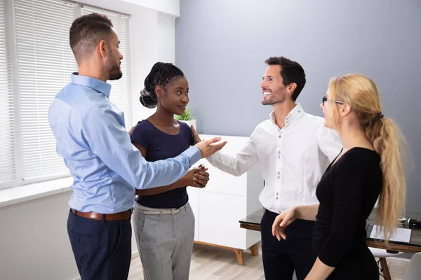 Young Male Executive Introducing New Hire Employee To Corporate Team At ...