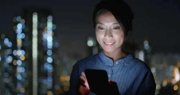 Woman check on mobile phone in city at night - Stock Image - Everypixel