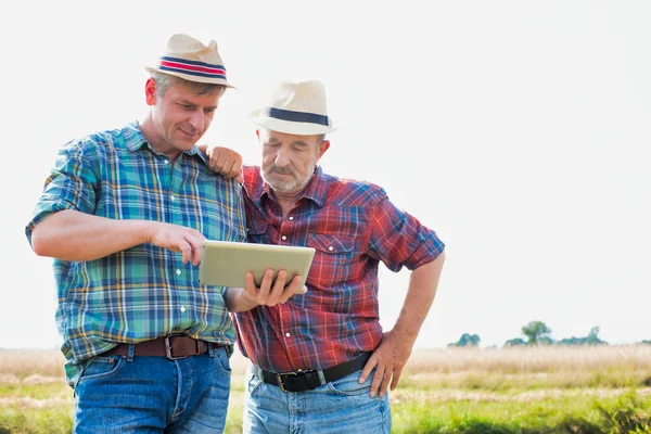Smiling farmers communicating over digital tablet at farm - Stock Image ...