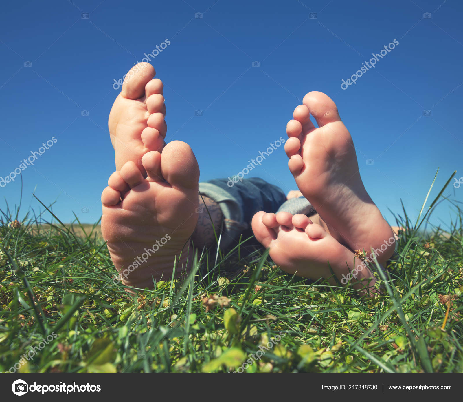 Woman Relaxing By Seaside Showing Her Dry Feet Sole Stock