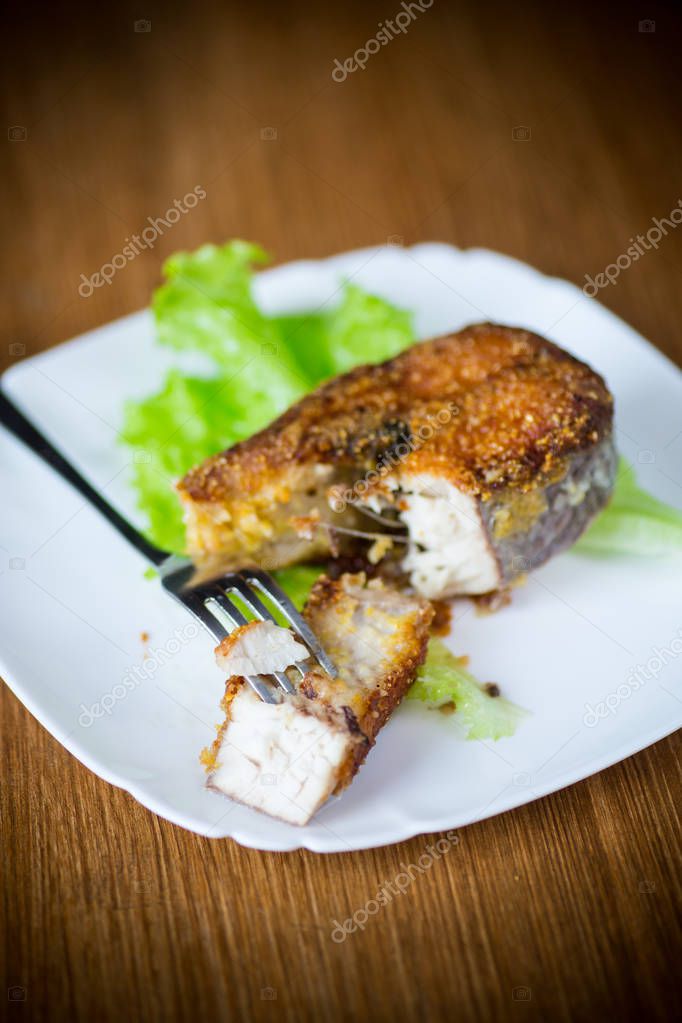 trozo de lucio frito en un plato de madera 2022