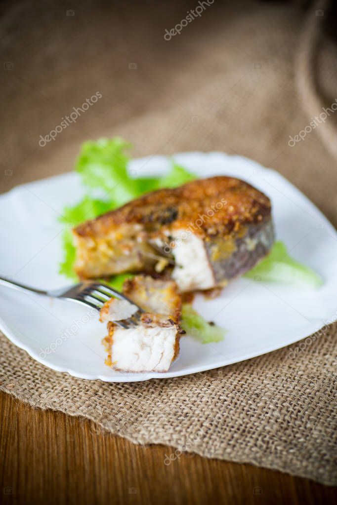 trozo de lucio frito en un plato de madera 2024