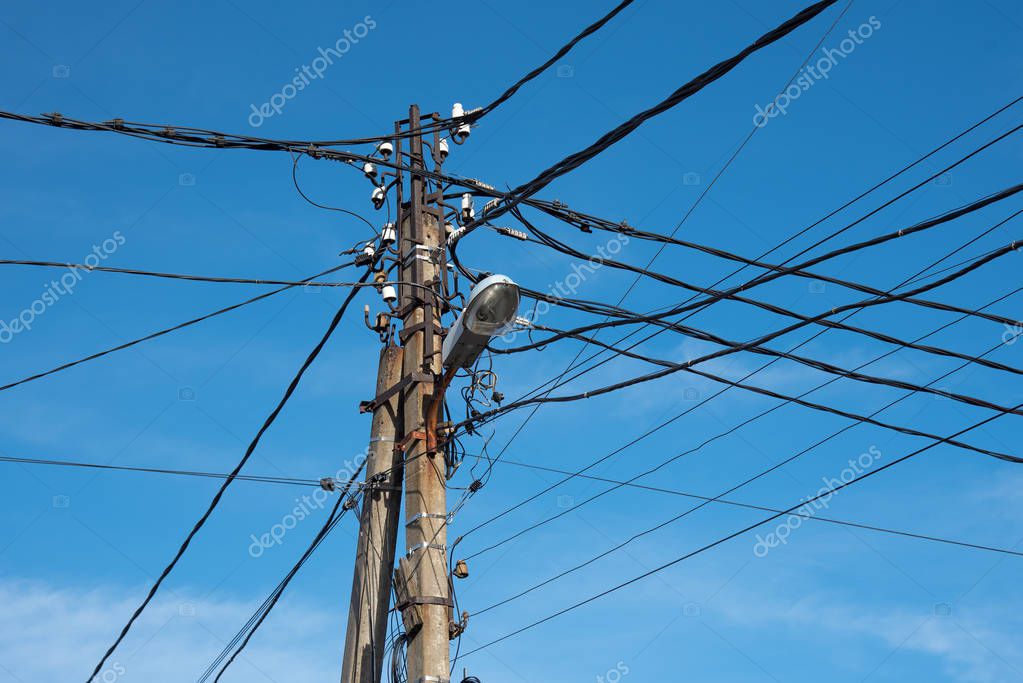 poste de hormigón con cables eléctricos y telefónicos y una farola 2024