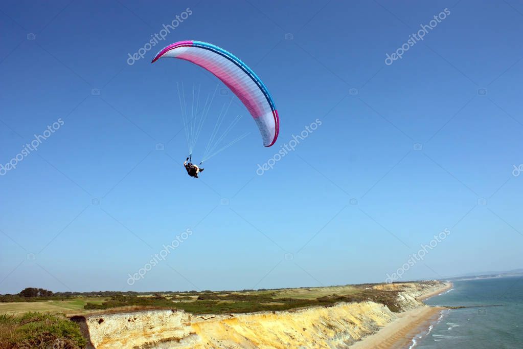 parapente vuela a través del aire sobre el mar, sobre un fondo del ...