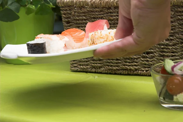 Hand reaching to the table sushi for picnic lunch - Stock Image ...