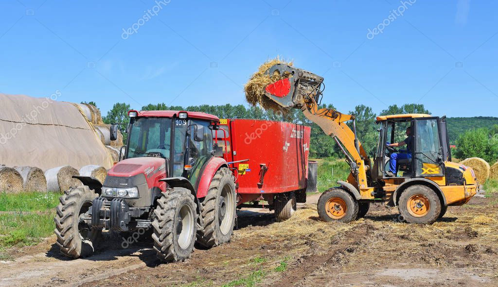 Kalush, Ukraine - July 14, 2017: A universal loader loads the trailed ...
