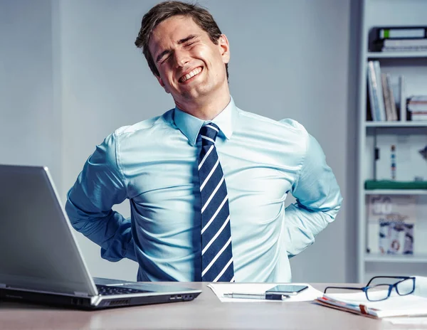 Employee suffers from severe pain in back. Photo of man working in the ...