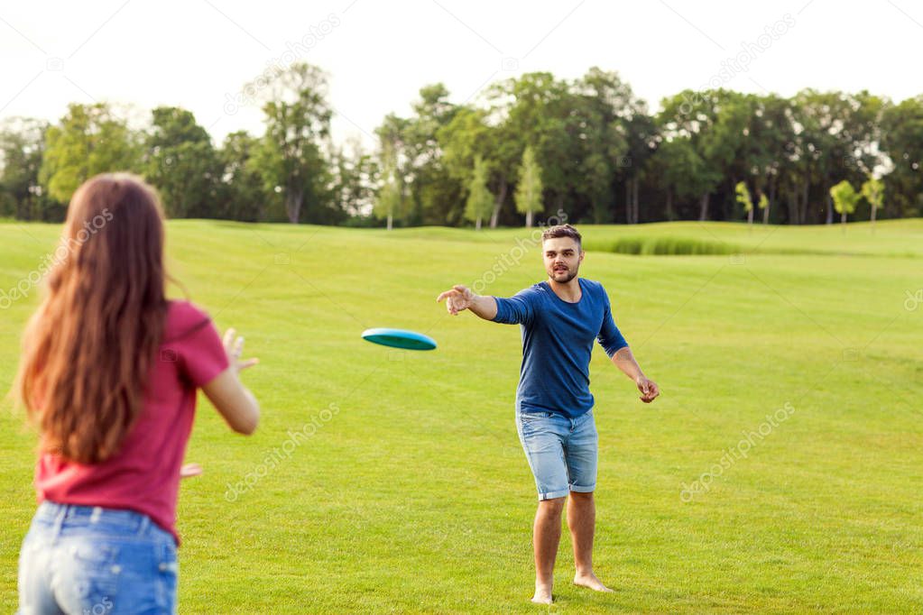 pareja enamorada jugando frisbee en el parque, el concepto de un estilo ...