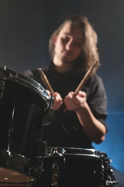 Close-up detail of a drum set against a blurred out-of-focus drummer with drum sticks - Stock ...