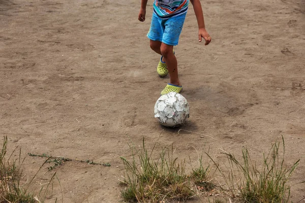 Old worn shabby and torn soccer ball on field of rural abandoned ...