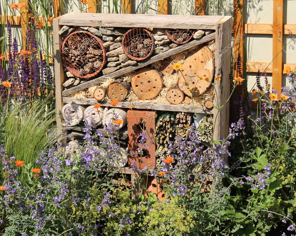 Una casa de insectos y insectos en un hermoso jardín de flores. 2023