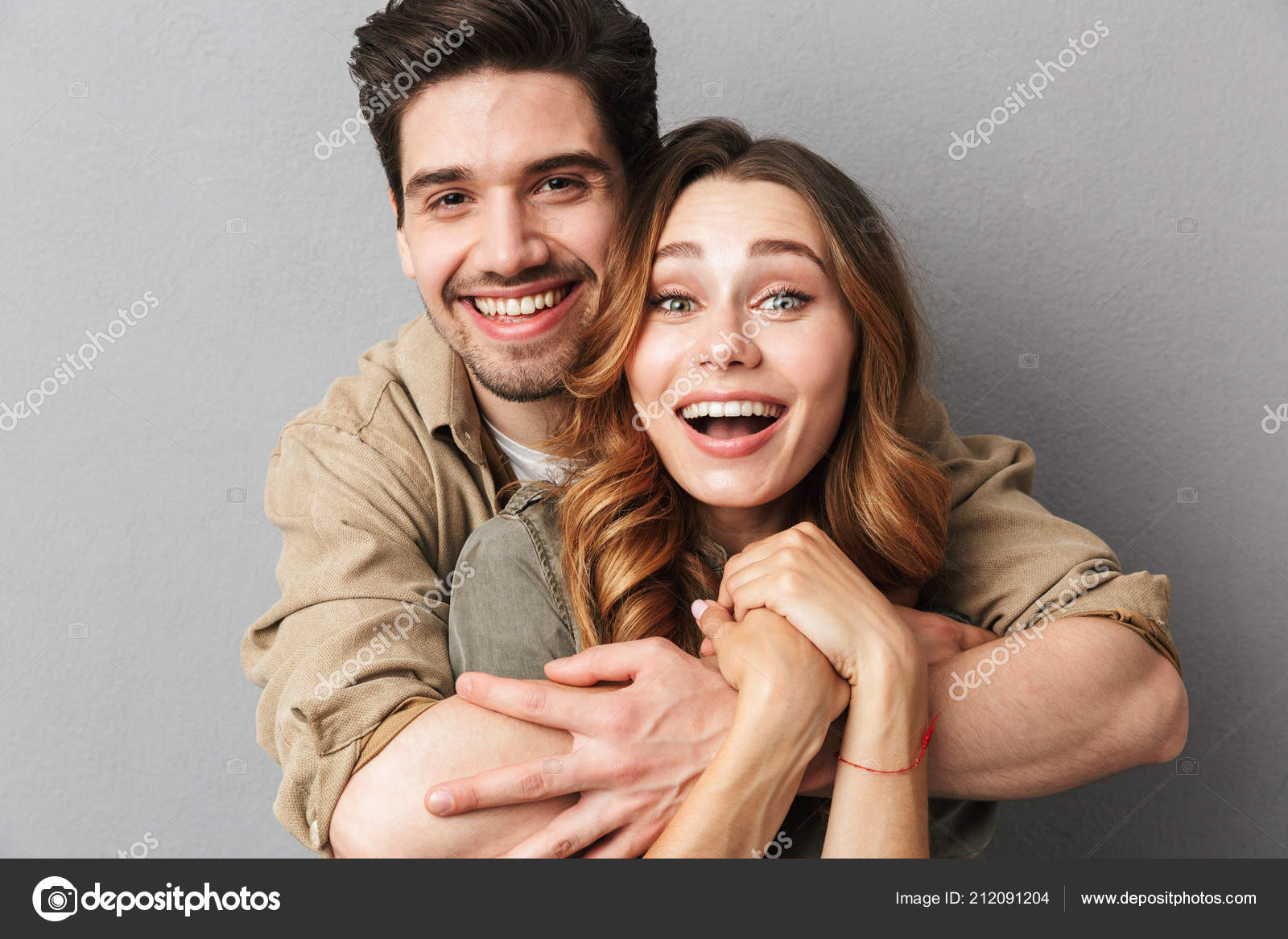 Excited Young Couple Hugging Looking Camera Isolated Gray Background ...