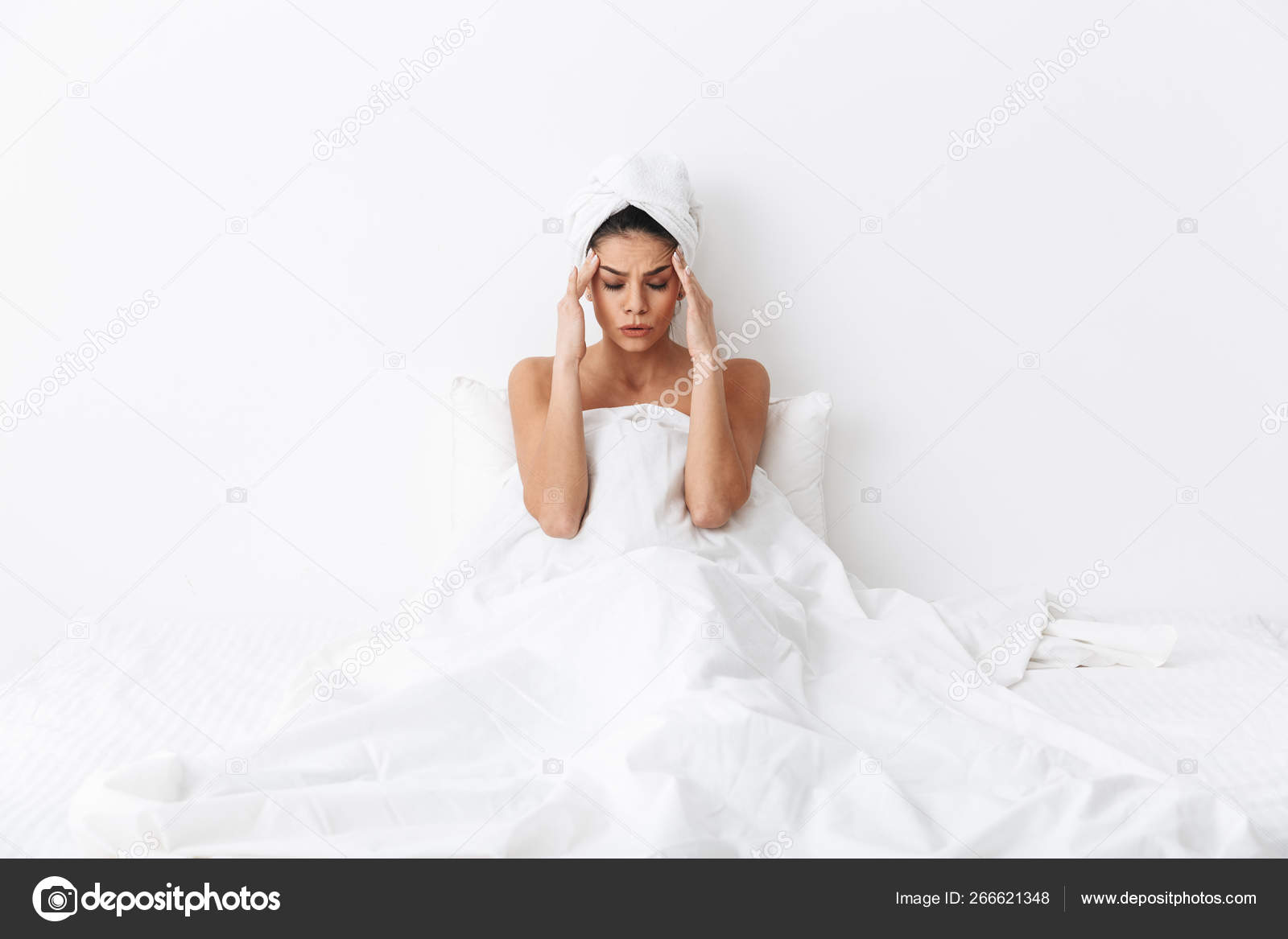 Sad amazing woman with towel on head lies in bed under blanket isolated ...