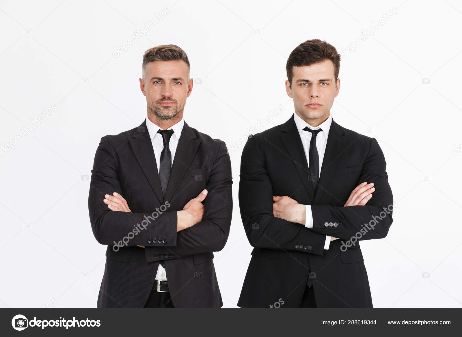 Image of masculine serious two businessmen in office suits looking at ...
