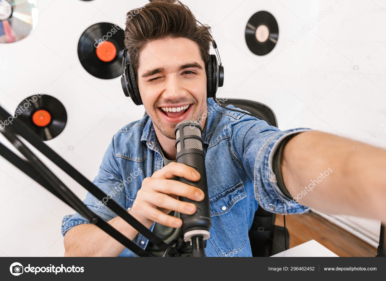 Handsome young man radio host at the workspace with microphone and ...