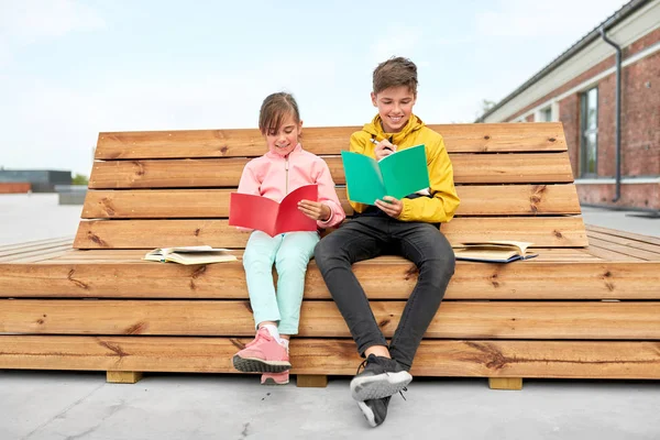 School children reading books sitting on bench Stock Photo by ©Syda ...