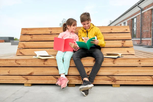 School children reading books sitting on bench Stock Photo by ©Syda ...