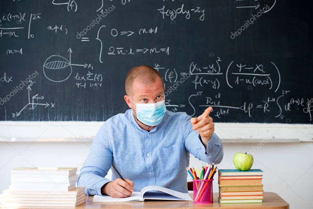 Profesor con máscara enseñando lección de matemáticas en la escuela ...