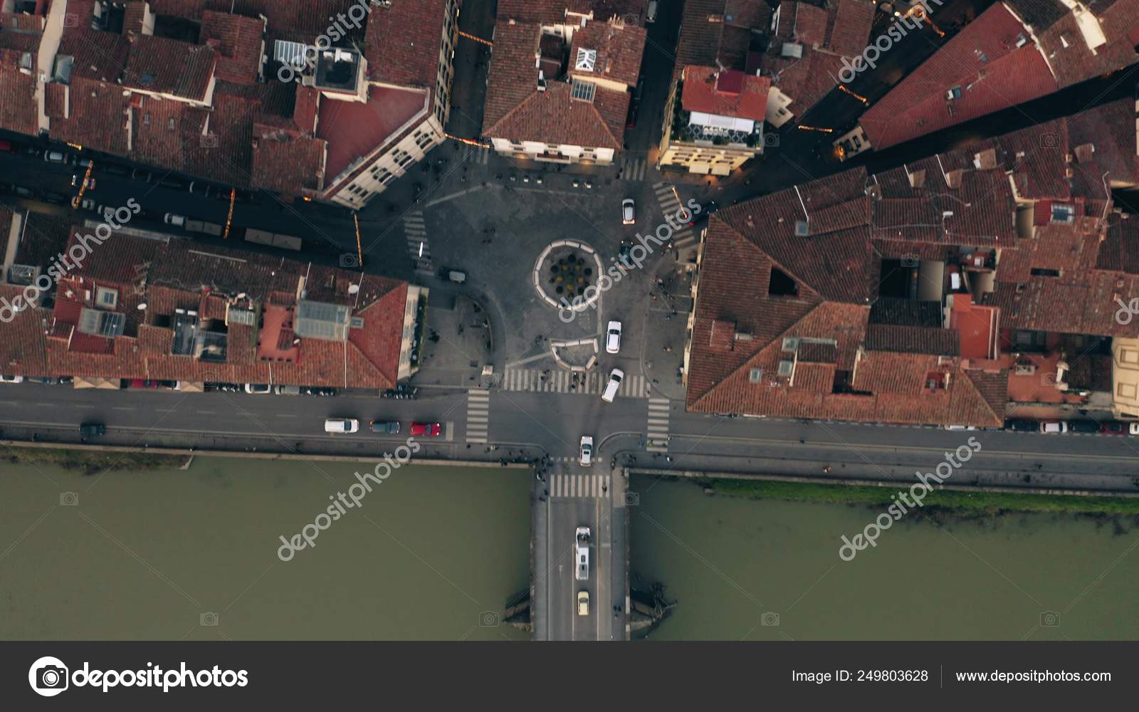 Aerial top down view of narrow streets, tiled roofs and the Arno river ...