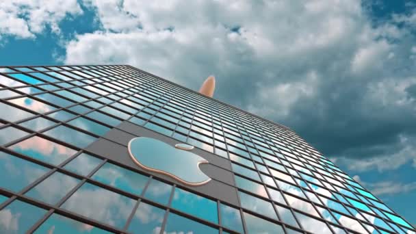 Apple Inc logo on a modern skyscraper reflecting clouds and flying ...