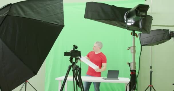 Blogger records a review video clip for social network on green screen ...