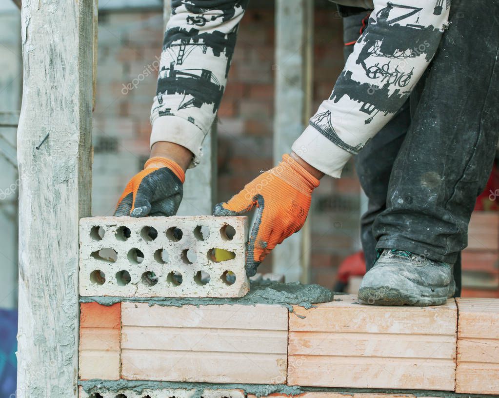 albañil industrial instalando ladrillos en obra. 2022