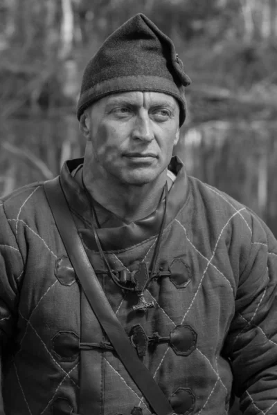 Man actor in viking clothes with a sword posing in the forest, black ...