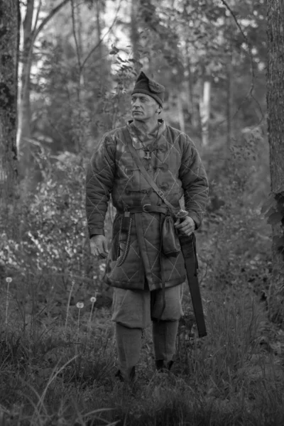 Man actor in viking clothes with a sword posing in the forest, black ...