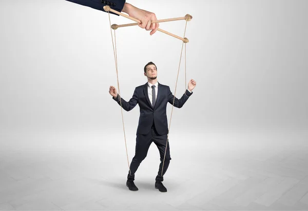 Puppet businessman leaded by a huge hand - Stock Image - Everypixel