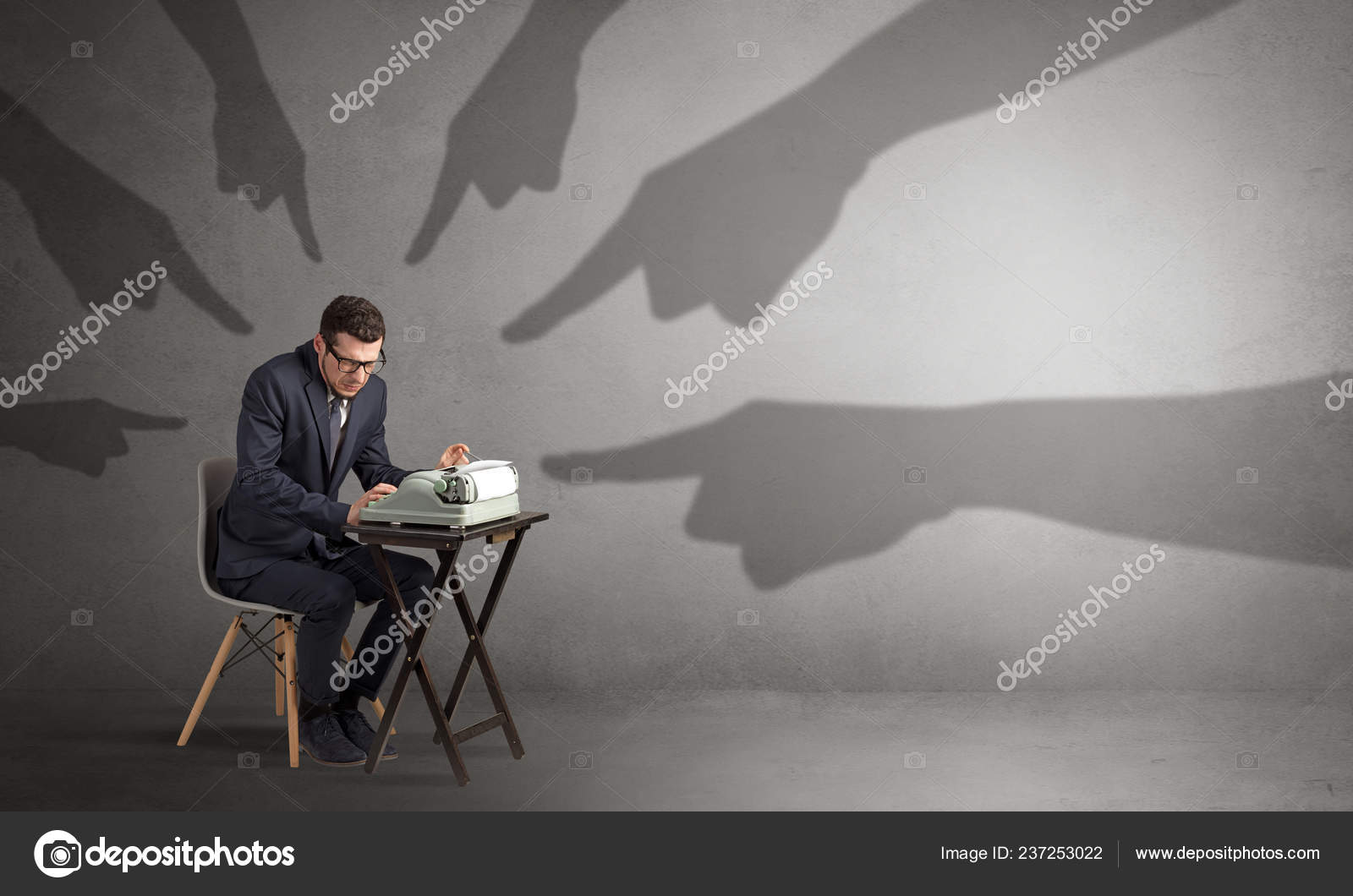 Shadow hands pointing at a small worker Stock Photo by ©ra2studio 237253022