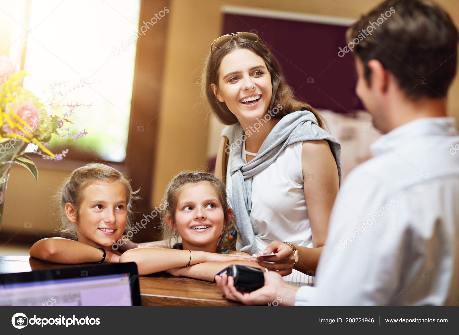 Happy family checking in hotel at reception desk Stock Photo by ...