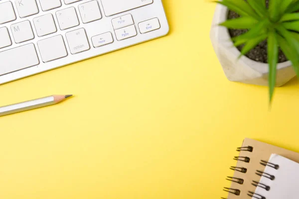 Yellow desk office with laptop, smartphone and other work supplies with ...