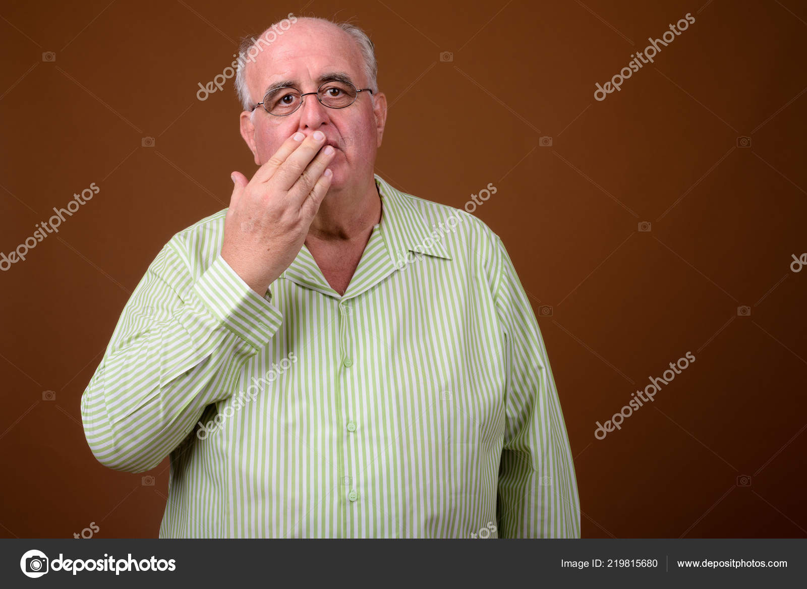 Overweight senior man wearing eyeglasses against brown backgroun Stock ...