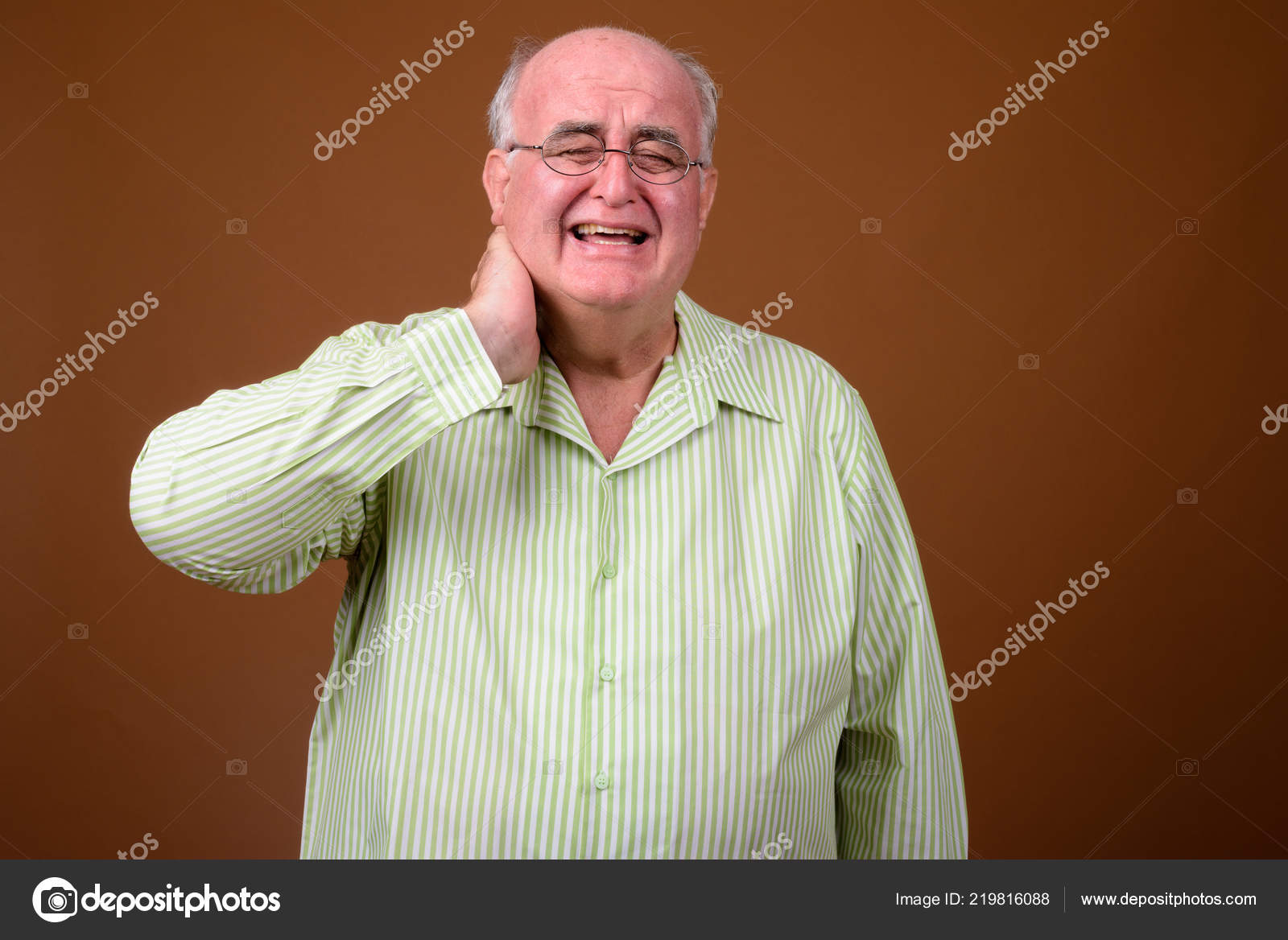 Overweight senior man wearing eyeglasses against brown backgroun Stock ...