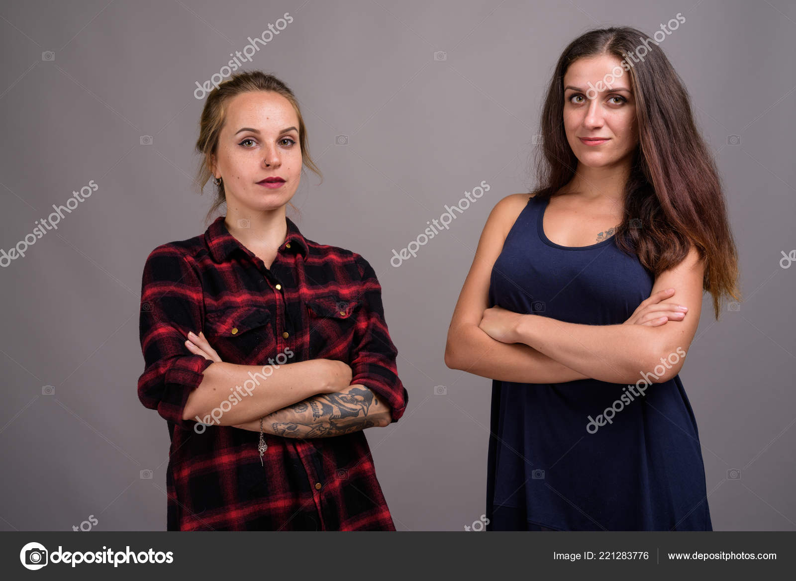 Portrait of two confident young beautiful woman with arms crossed Stock ...