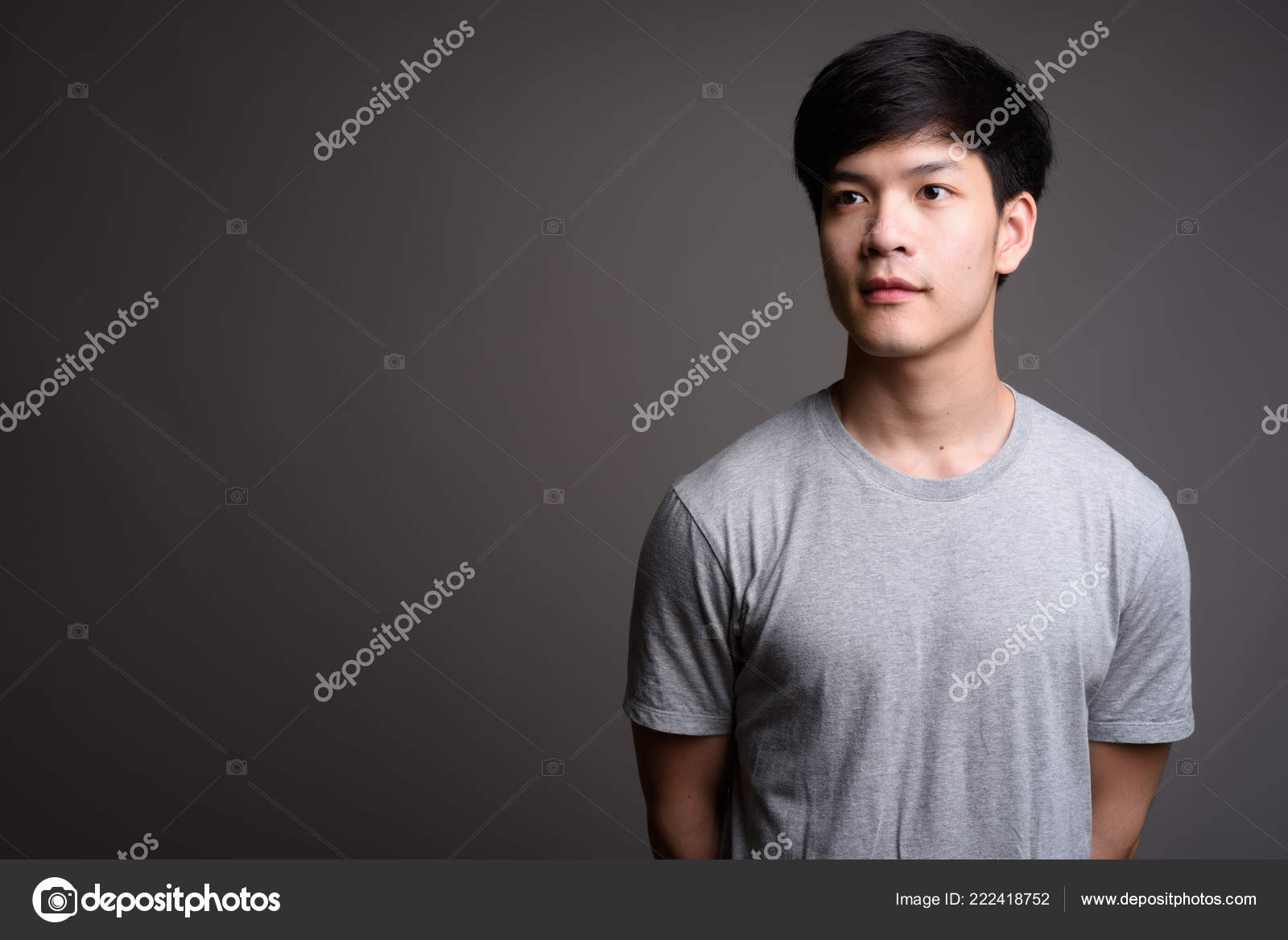 Young handsome Asian man thinking against gray background Stock Photo ...