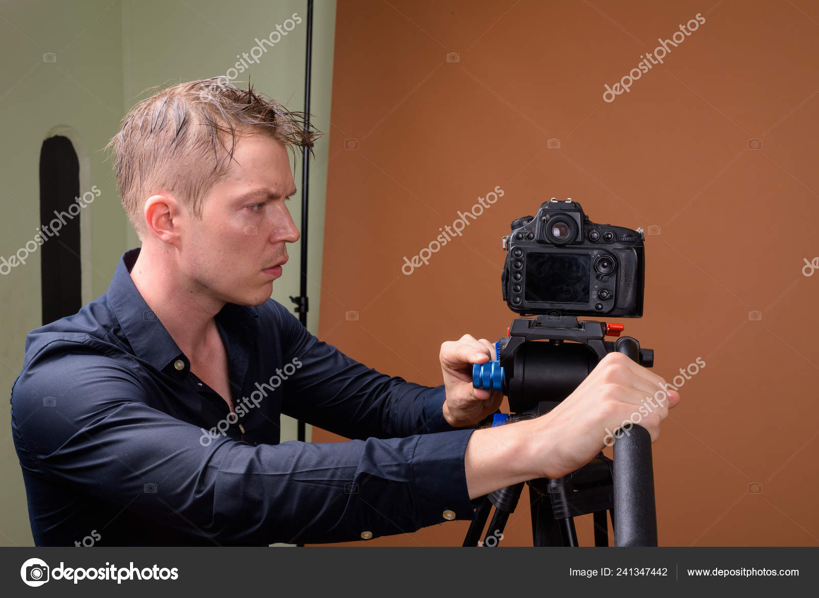 Young man photographer adjusting camera on tripod — Stock Photo ...