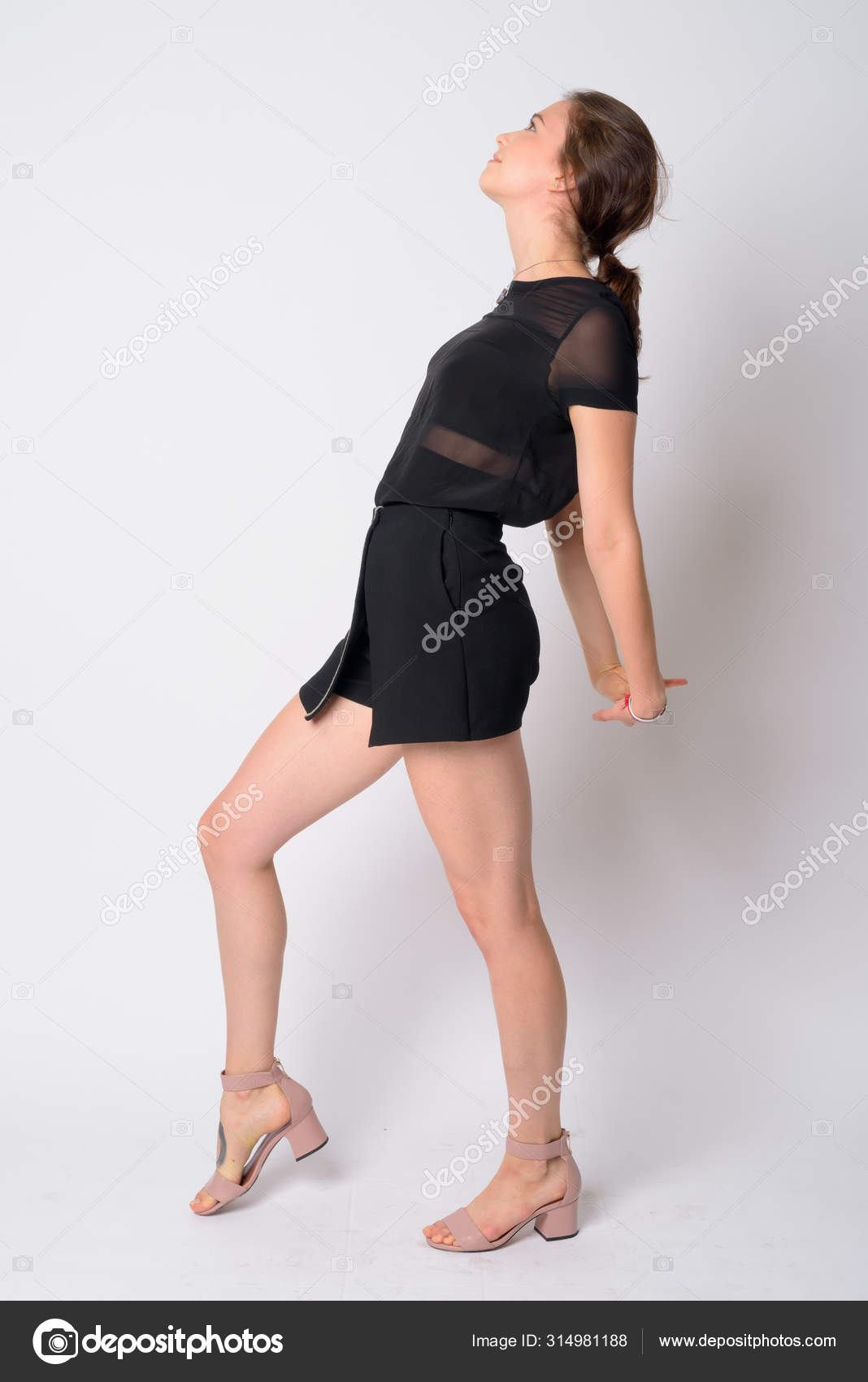 Full body shot profile view of young beautiful woman stretching arms ⬇ ...