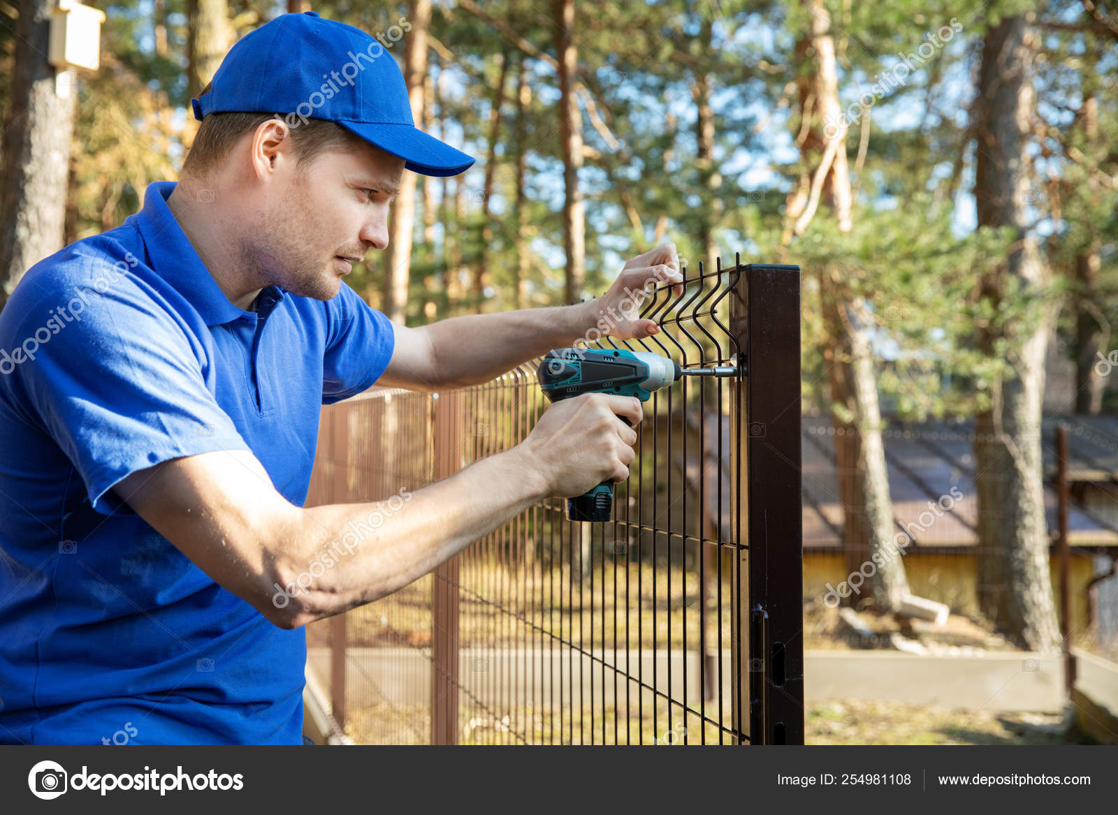 Fencing services - worker installing welded metal mesh fence — Stock ...