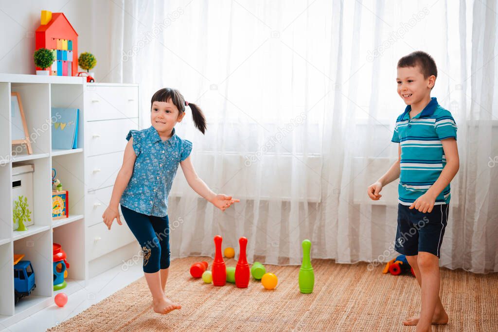 niño nativo y una niña juegan en una sala de juegos para niños, lanzando pelota. concepto de ...