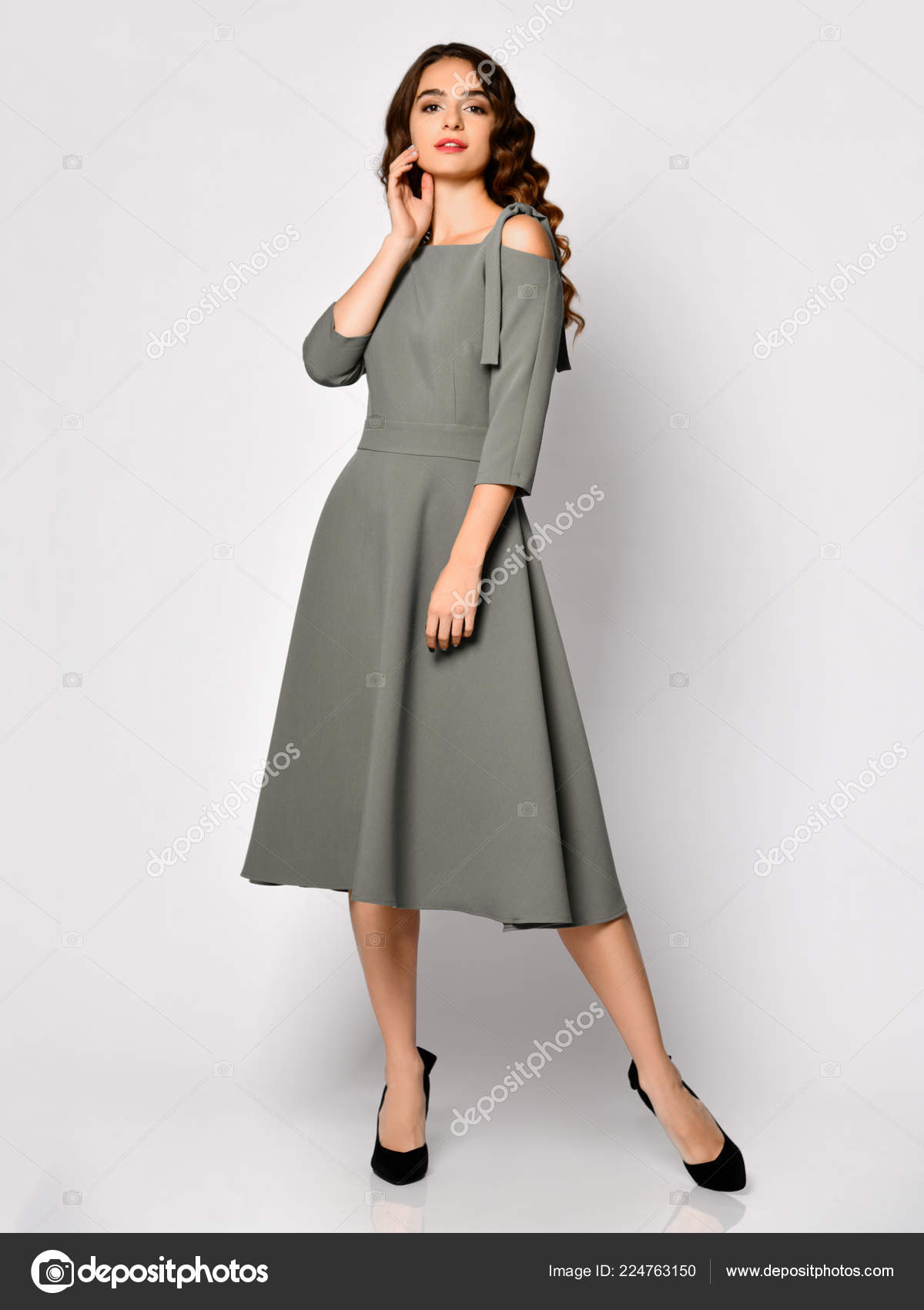 Young beautiful woman posing in new gray fashion winter dress on high ...