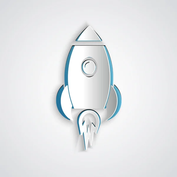Paper cut Rocket ship with fire icon isolated on grey background. Space travel. Paper art style ...