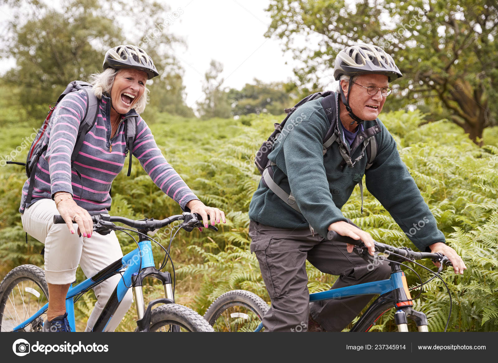 Senior Couple Riding Mountain Bikes Countryside Camping Holiday Side ...