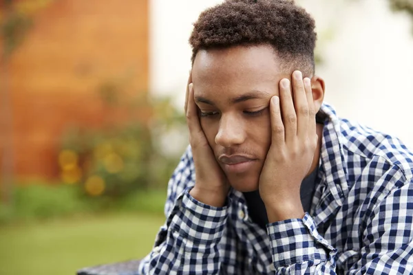 Depressed young black man with head in hands, close up, head and ...