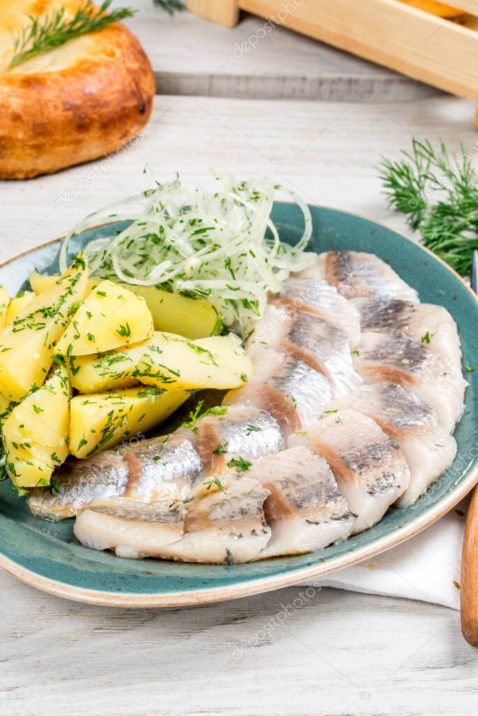 Arenque salado con patatas hervidas en un hermoso plato. Primer plano ...