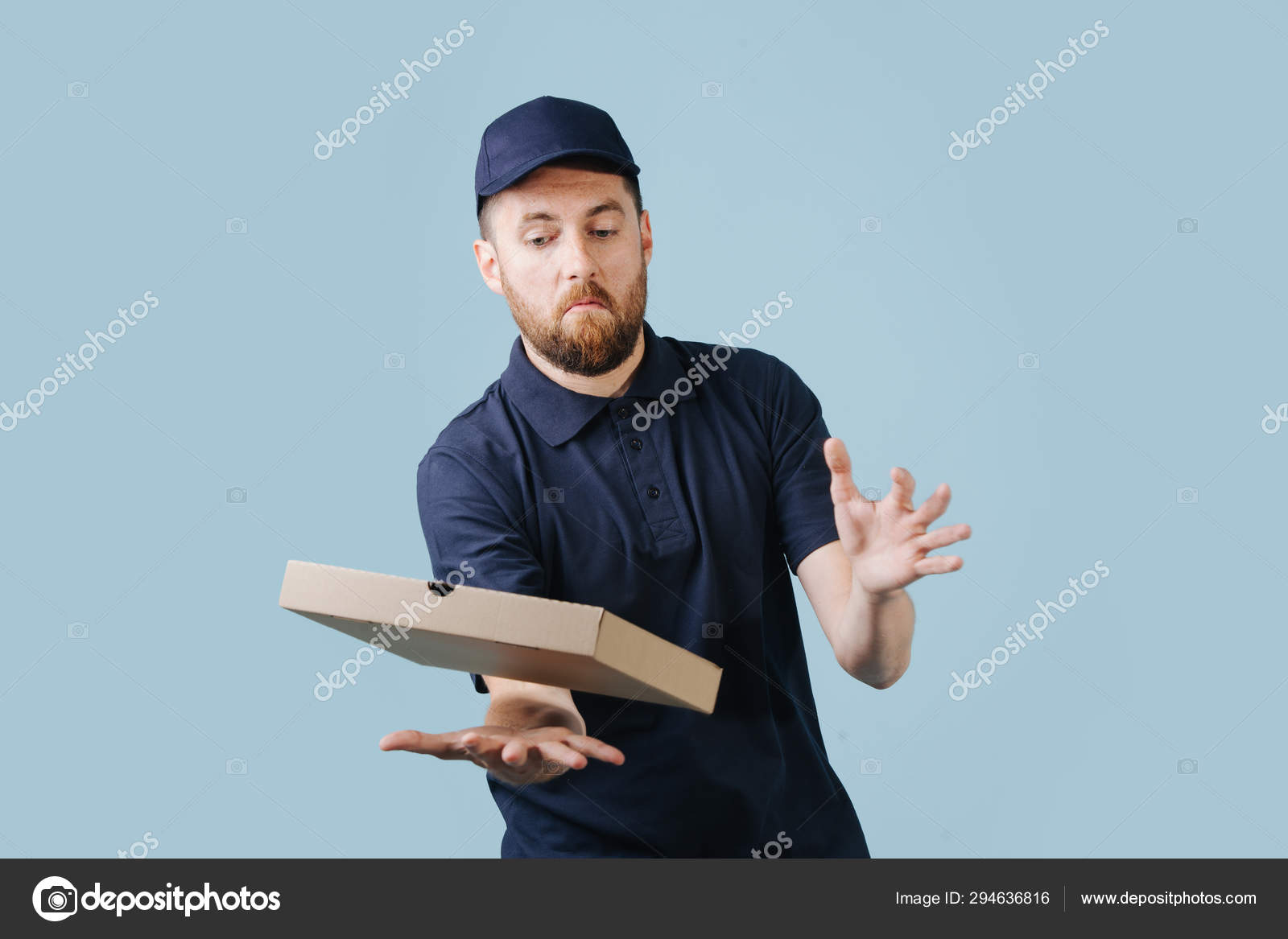 Clumsy, funny delivery man is dropping cardboard pizza box, trying to ...